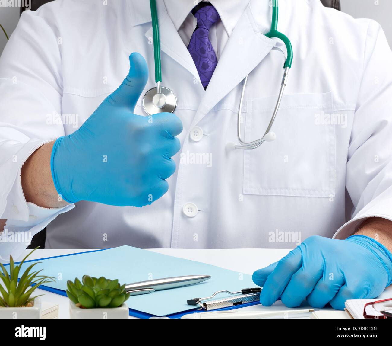 doctor in a white coat and tie shows with his hand a gesture like ...
