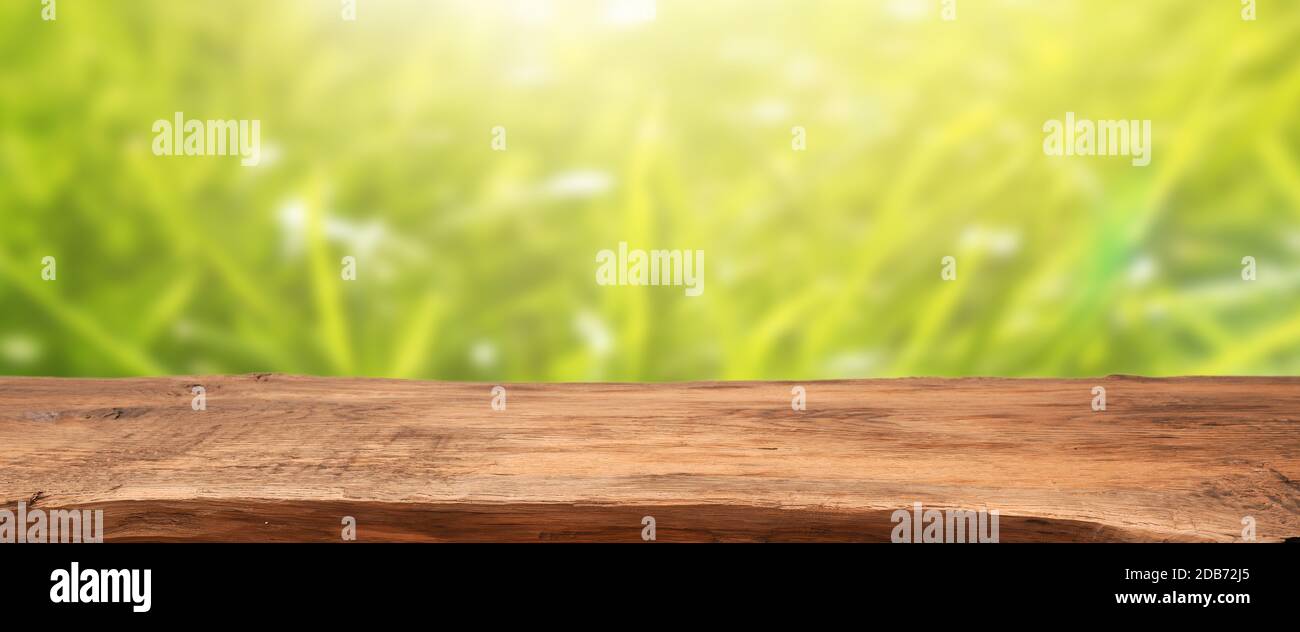 Empty wooden plank or table with grass or meadow background, natural ...