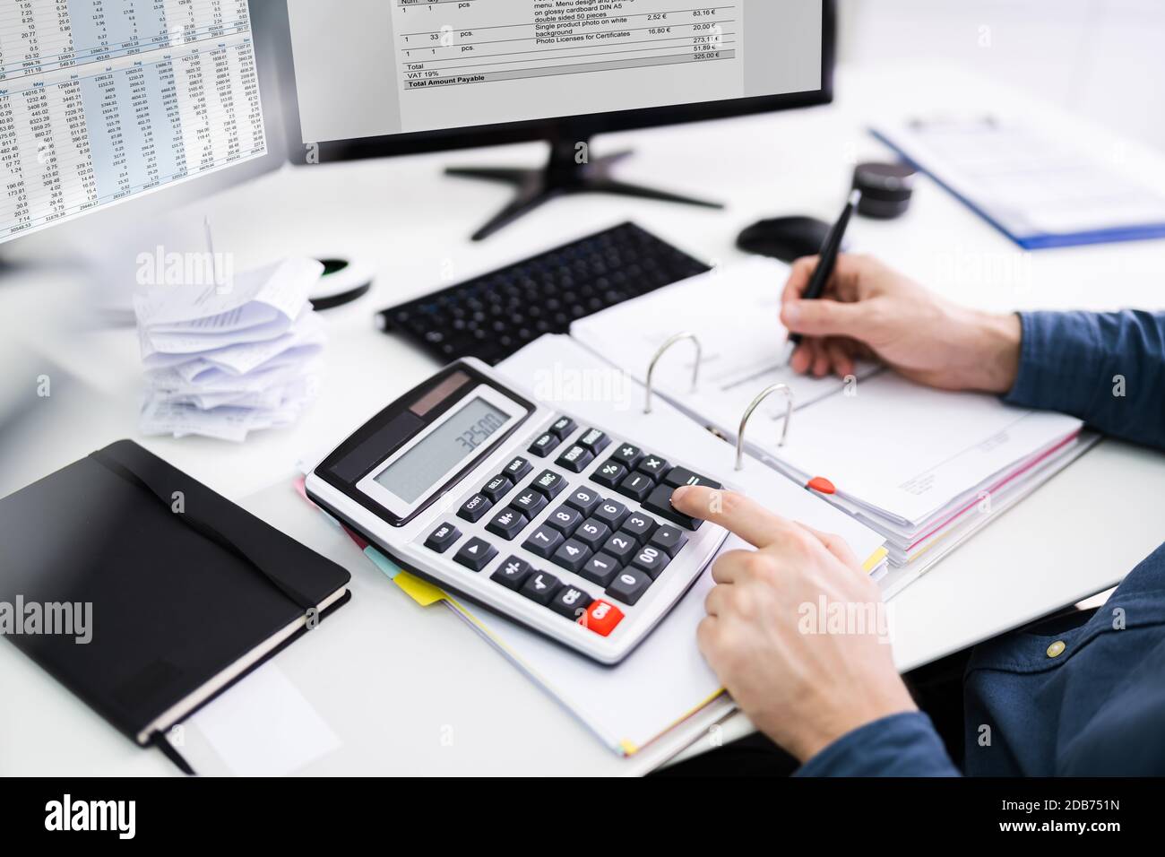 Young Businessman Calculating Bill With Computer And Laptop On Desk ...