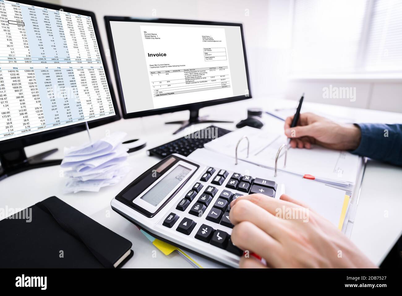 Young Businessman Calculating Bill With Computer And Laptop On Desk ...