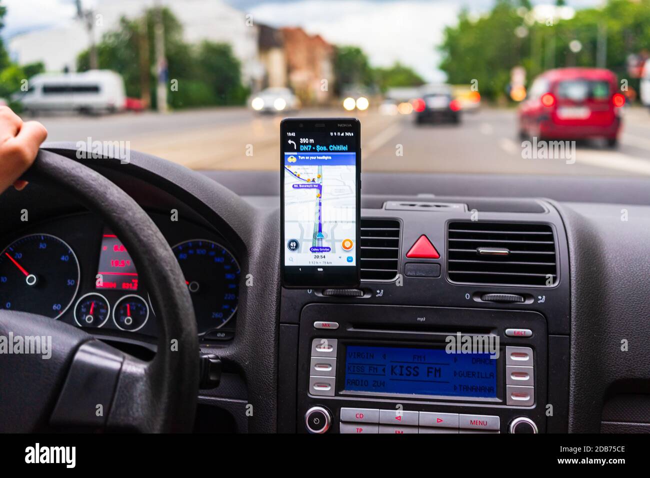 Driving and using waze maps application on smartphone on car dashboard ...