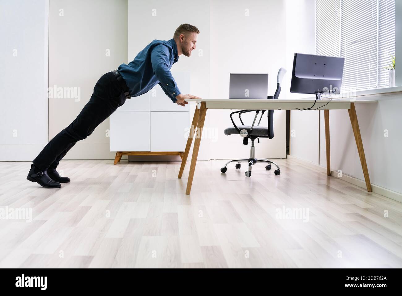 Side View Of A Young Businessman Doing Push Up On Office Desk Stock ...
