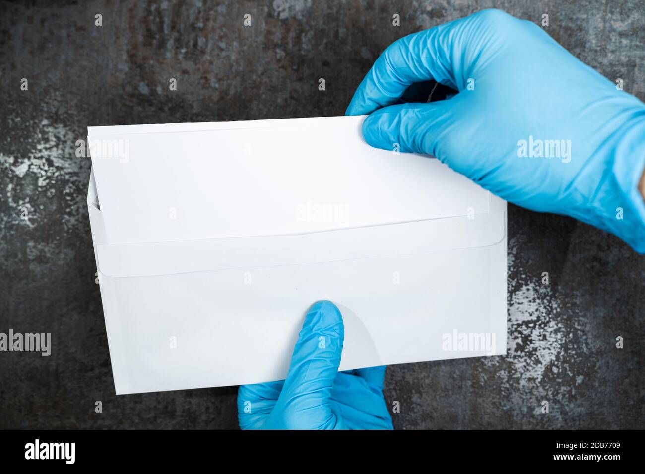 Elevated View Of A Person Removing Paper From Envelope Over Office Desk ...