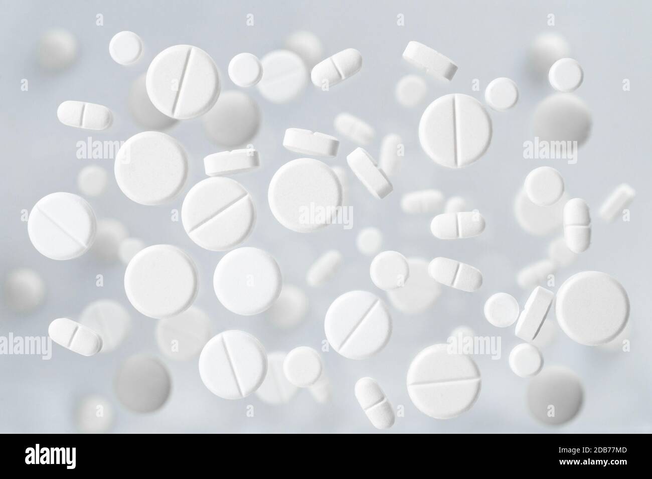 Medical background of floating white pills and vitamins Stock Photo - Alamy