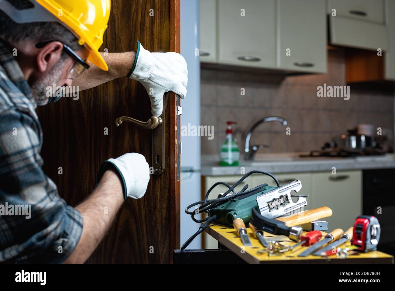 Close-up. Carpenter at work repairs and installs the new lock of a ...
