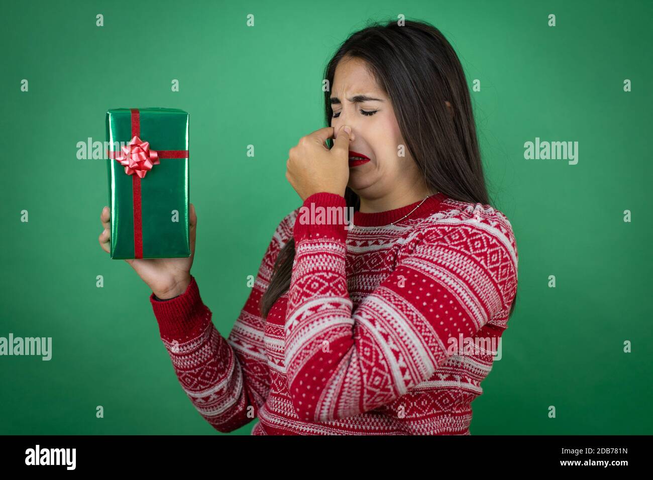 Young beautiful girl holding gift over isolated white background ...