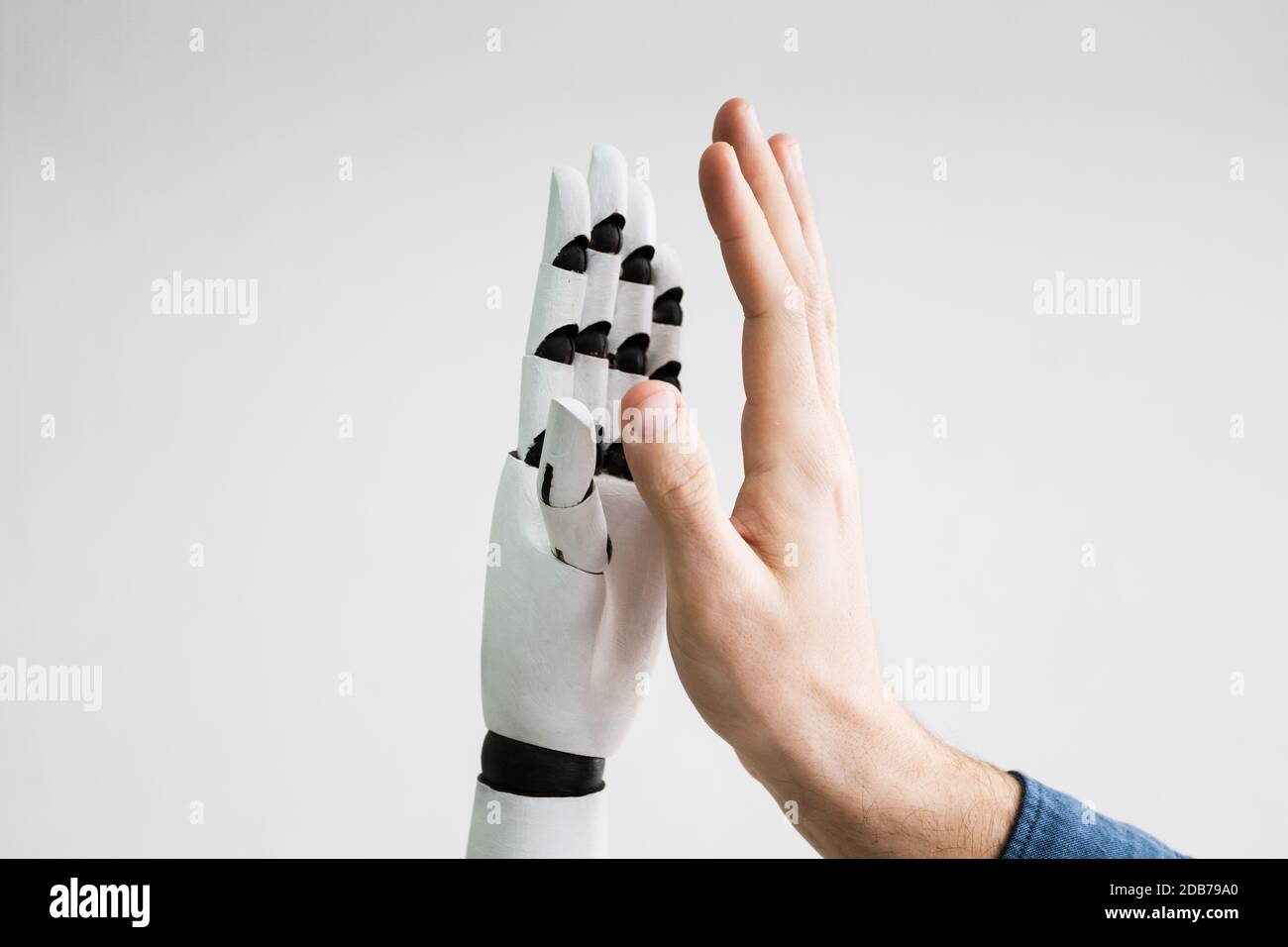 Close-up Of Robot And Man Giving High Five Against Gray Background ...