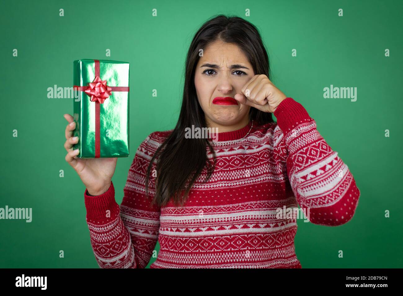 Young beautiful girl holding gift over isolated white background ...