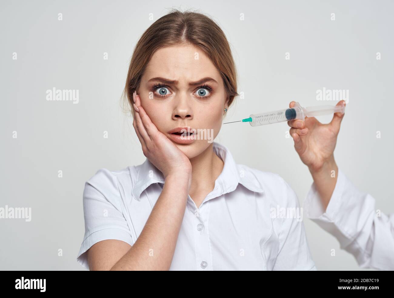 scared woman and syringe with needle near face Stock Photo - Alamy