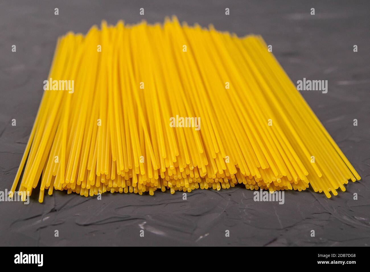 Yellow long spaghetti on a dark background. Front views Stock Photo - Alamy