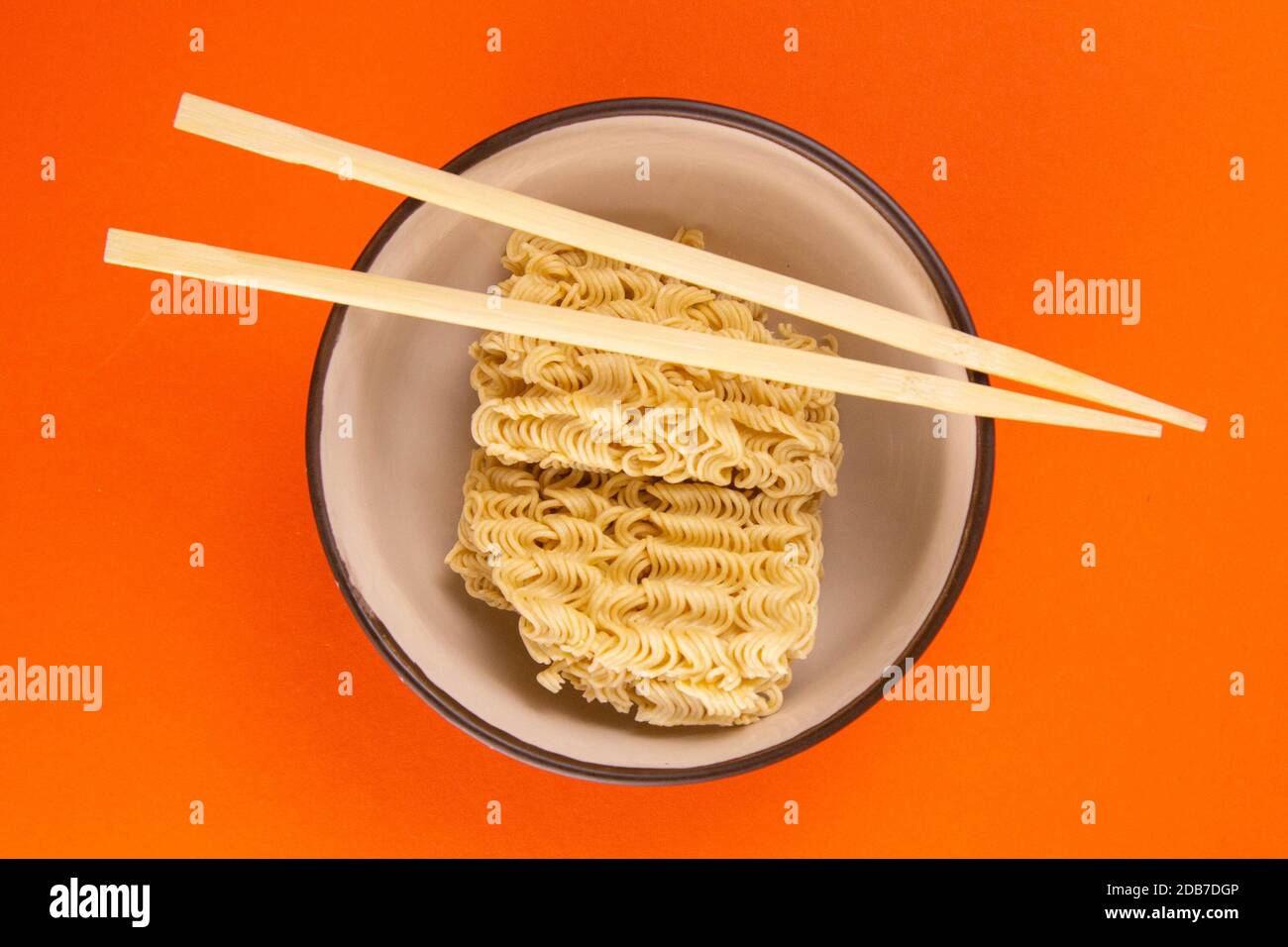 Instant noodles with wood sticks. Asian fast food on a orange ...