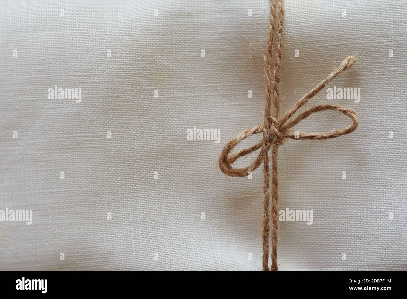 Twine tied in a bow. Close-up. Fabric background Stock Photo - Alamy