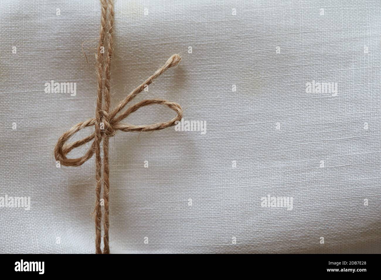 Twine tied in a bow. Close-up. Fabric background Stock Photo - Alamy