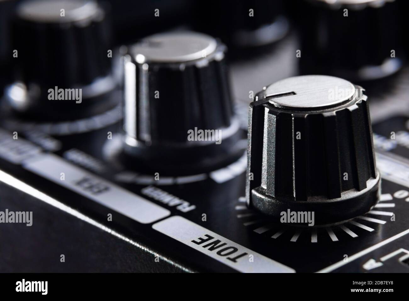 selective focus on the tone knob of an amplifier for electric musical ...