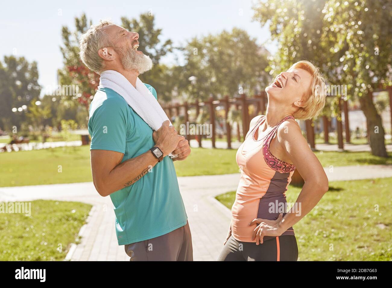 Being fit. Happy sporty senior couple having fun while resting after ...
