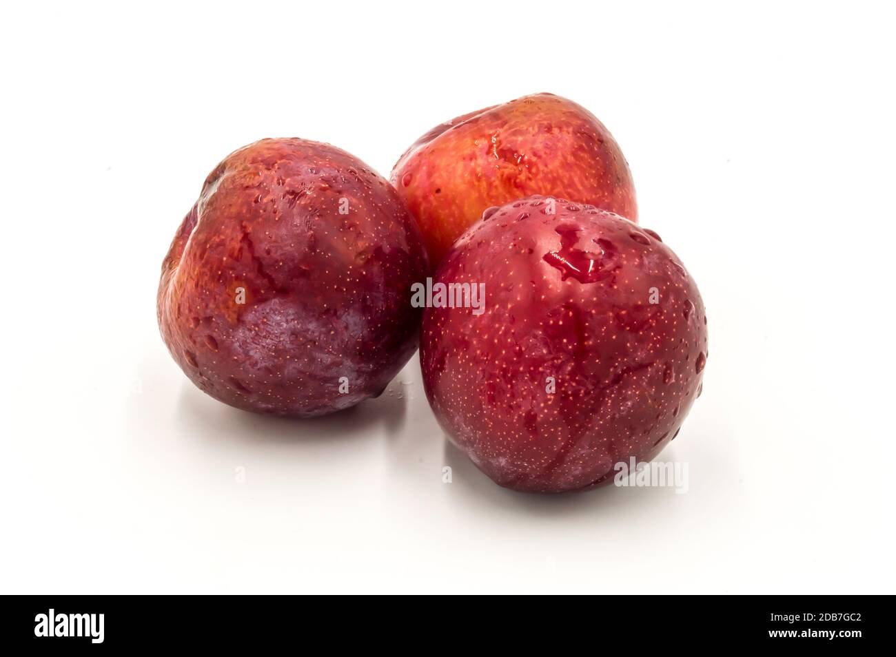Three ripe red round plums isolated on white. Big plan Stock Photo - Alamy