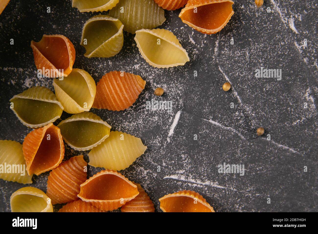 Pasta Conchiglie Rigate, mix of colorful uncooked shells scattered on ...
