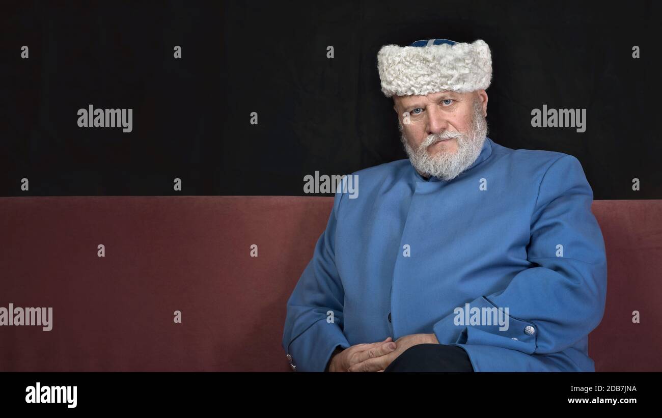 elderly man with a gray beard in a hat and a blue caftan. Cossack ...