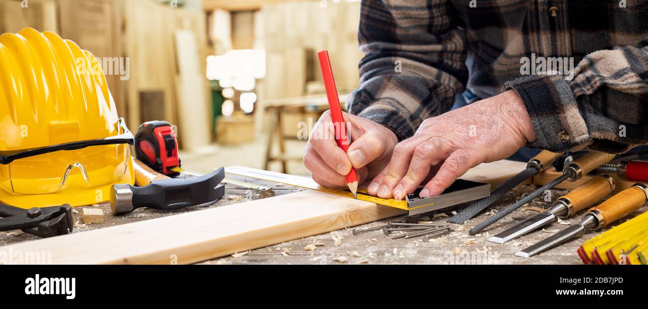 Close-up. Carpenter with pencil and carpenter's square draw the cutting ...