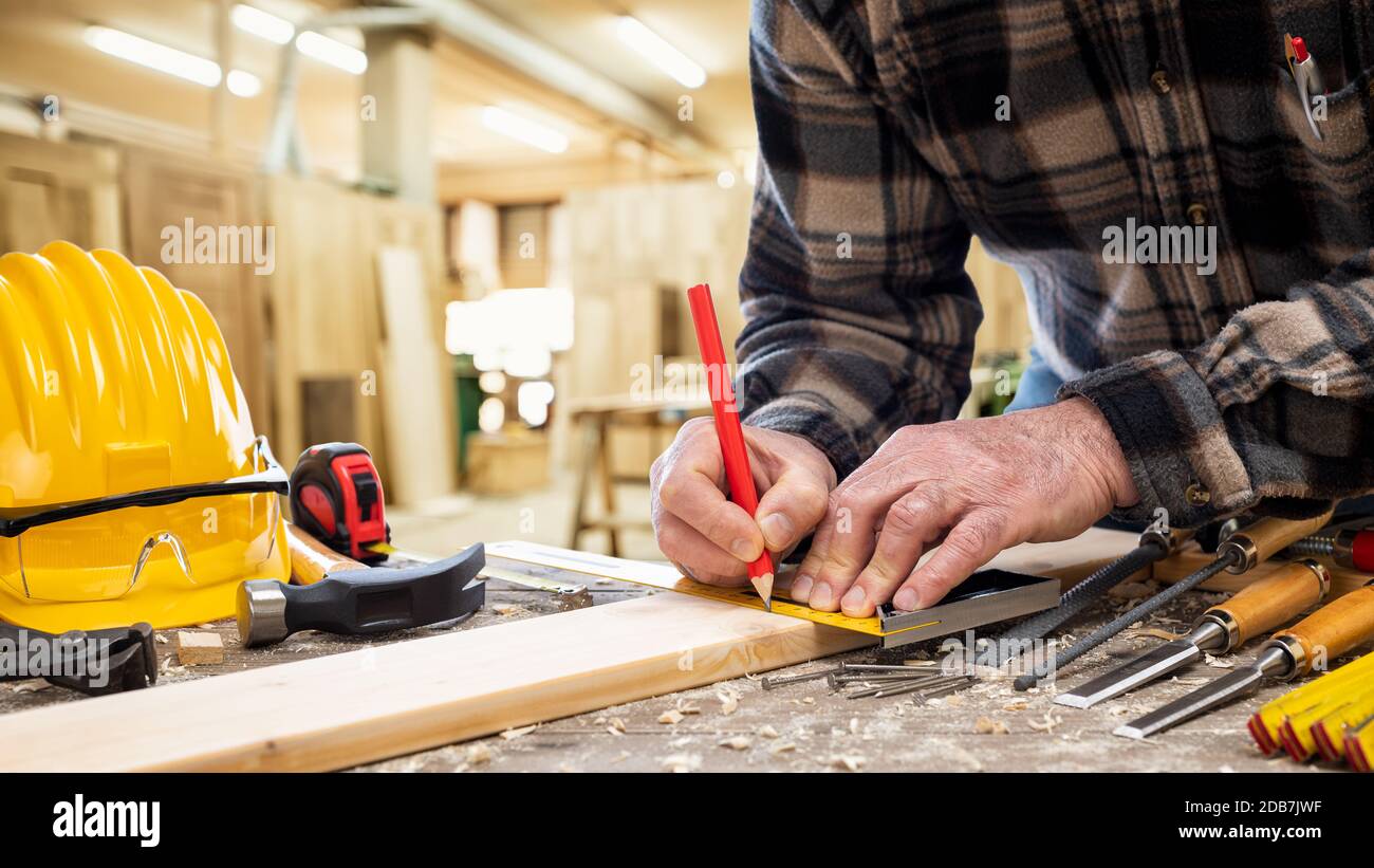 Close-up. Carpenter with pencil and carpenter's square draw the cutting ...