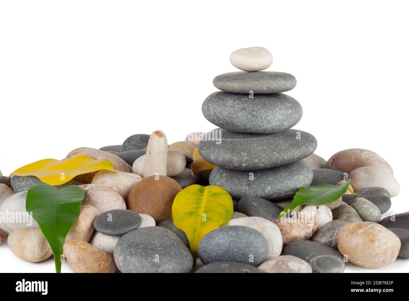 The pyramid of round stones with leaves isolated on white background ...