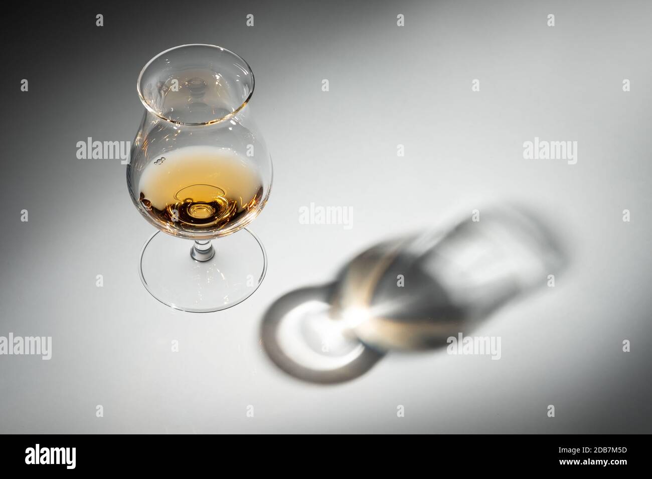 Glass of whisky with shadow hovering in the air Stock Photo - Alamy