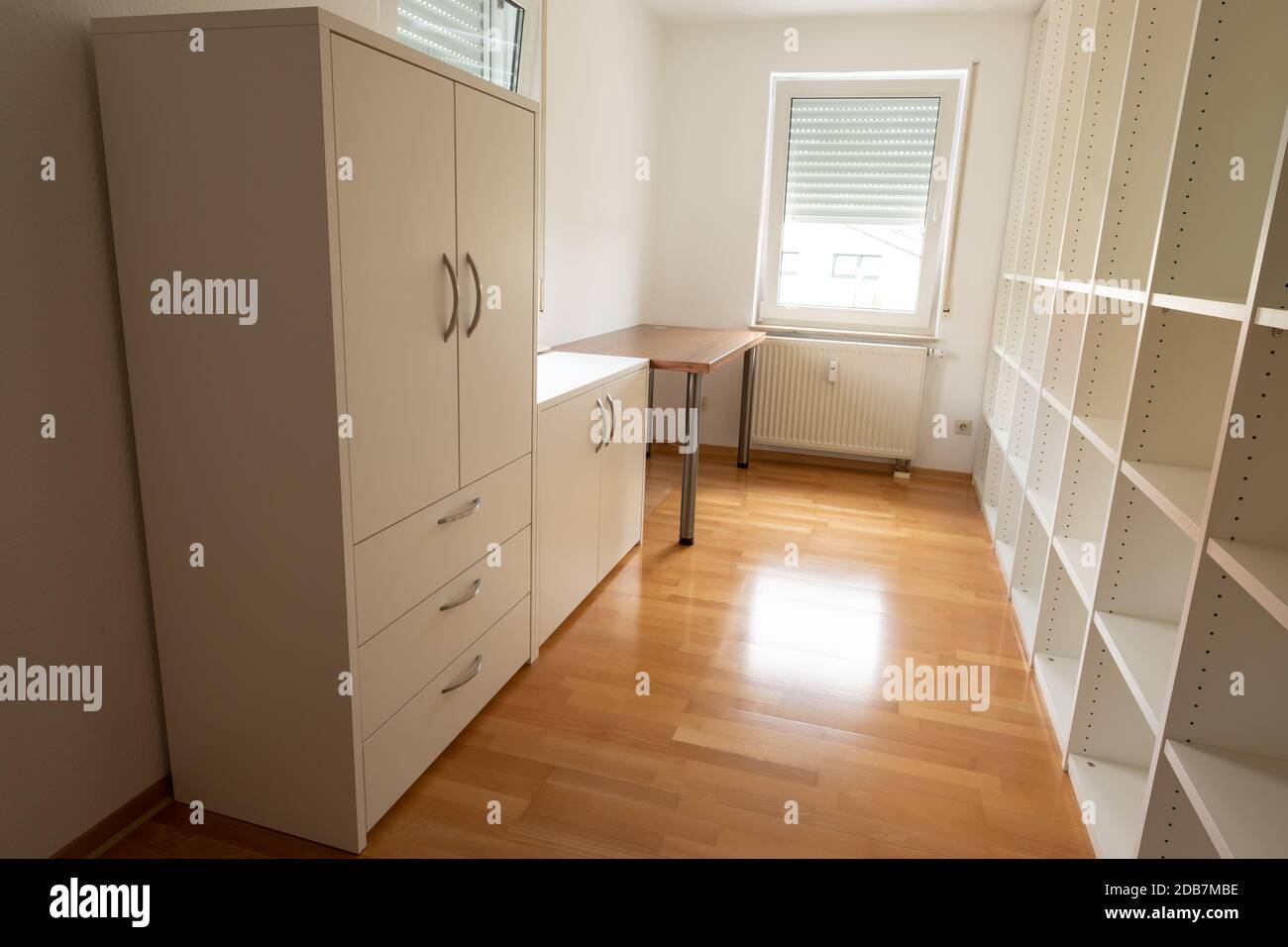Office room with white rack cupboard and desk Stock Photo - Alamy