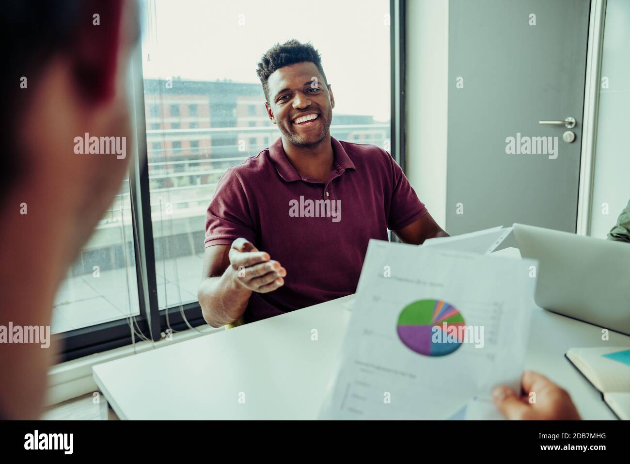 Businessman laughing with colleagues discussing numbers and figures ...