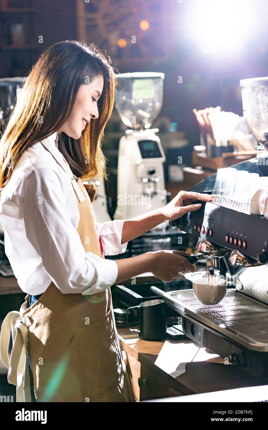 Side view shot of a barista brewing coffee by modern coffeemaker ...