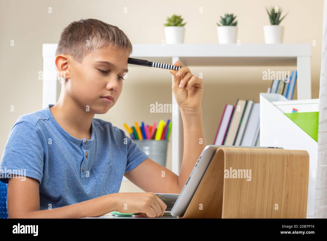 Teenage boy with digital tablet computer thinking, doing homework, have ...