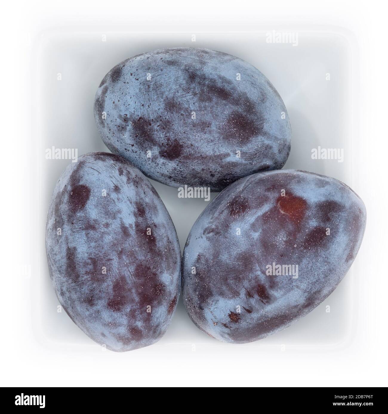 Blue ripe plums in a white bowl in top view Stock Photo - Alamy