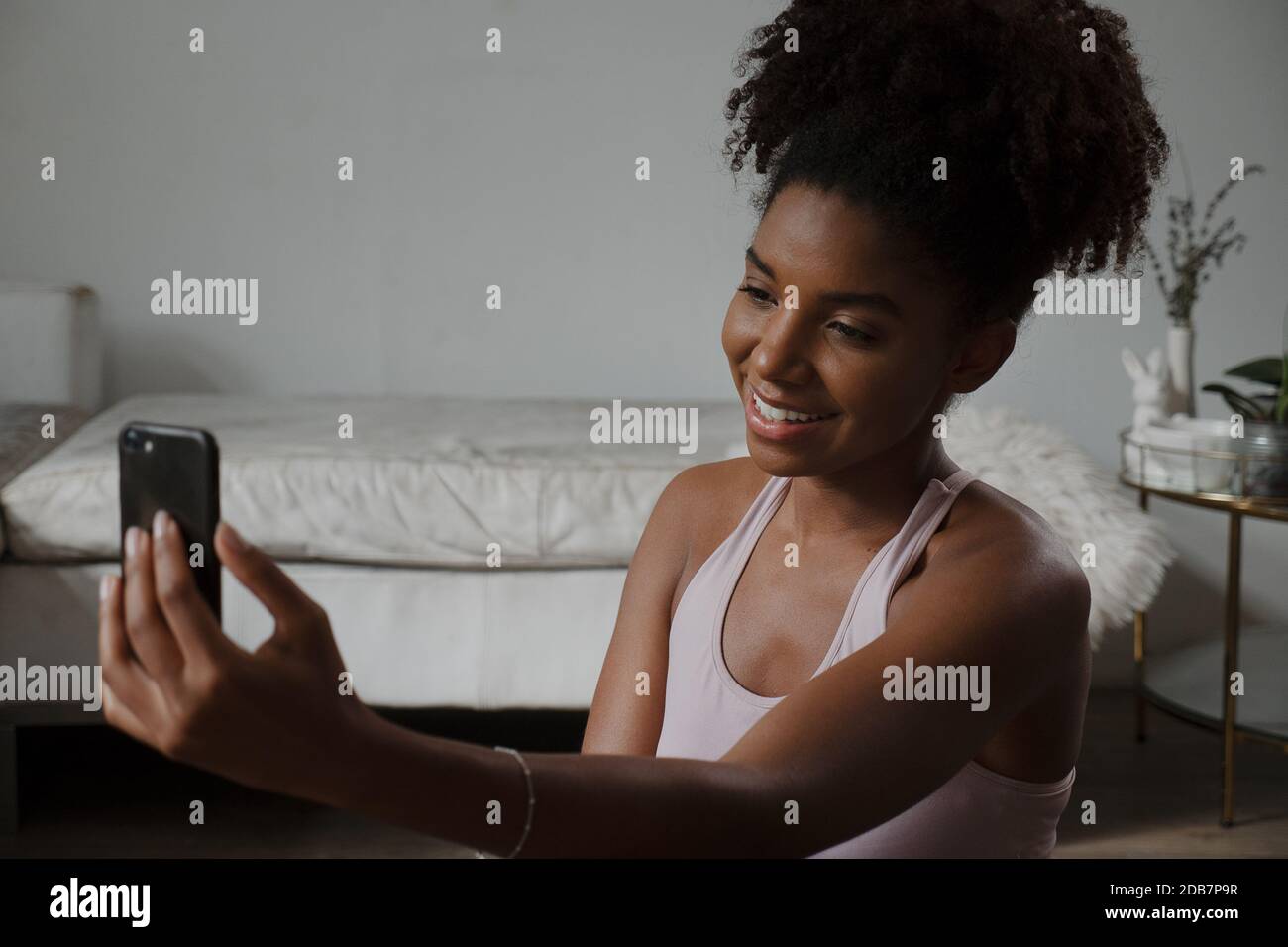 Ethnic female teen chatting to friends overseas on video call using ...