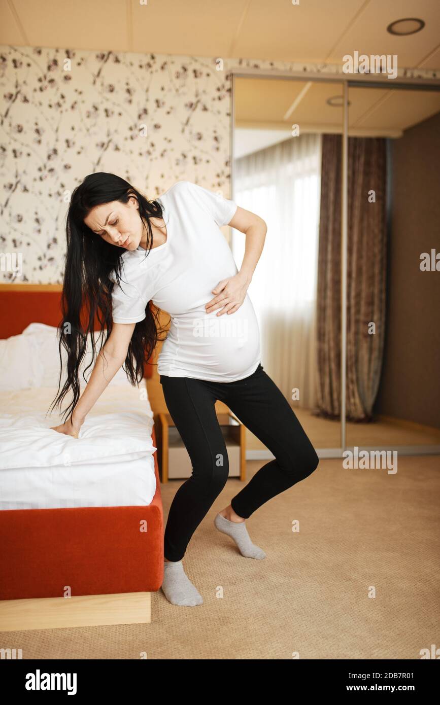 Pregnant woman with belly felt contractions at home. Pregnancy, calm in ...