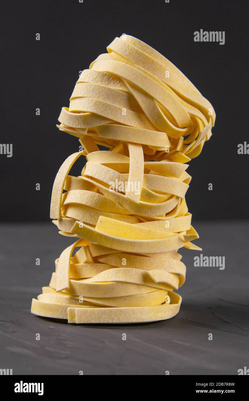 column raw dry nest pasta with reflection isolated on black. Front ...