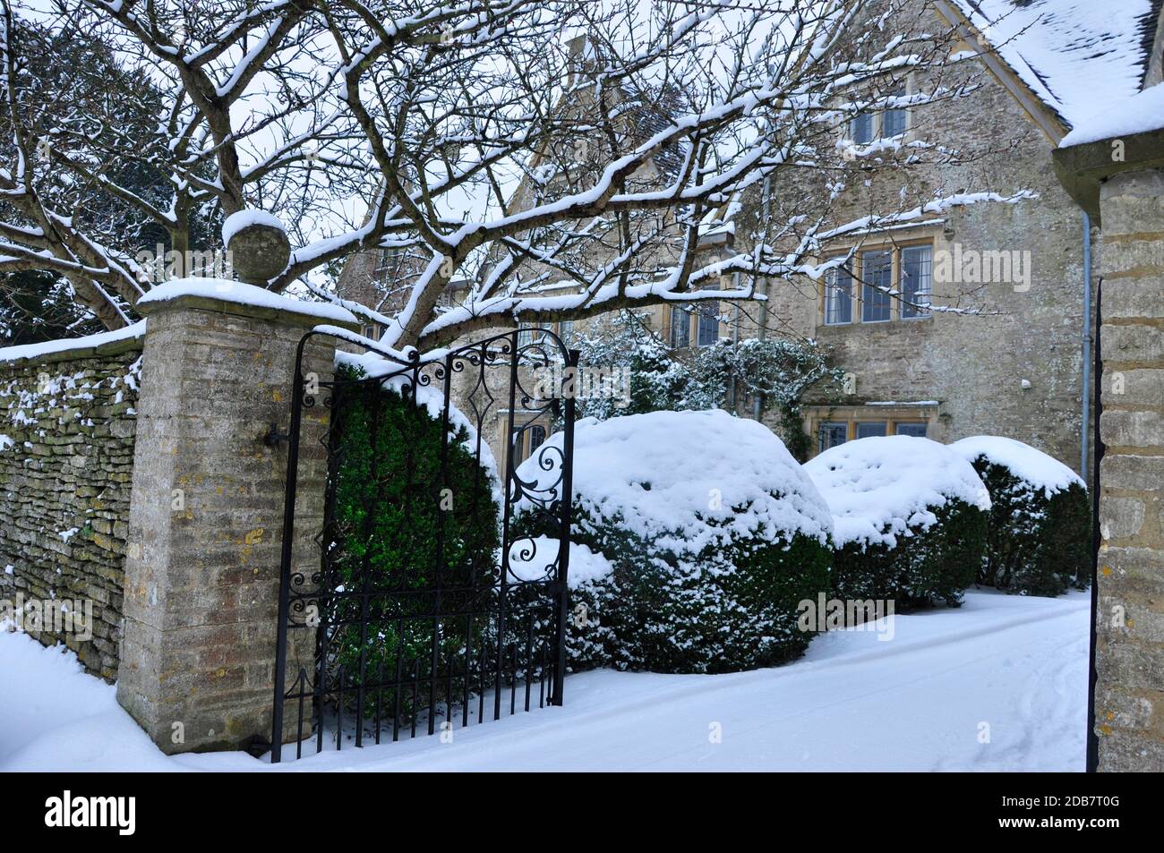 The snow covered entrance to a cotswold stone house in the village of ...