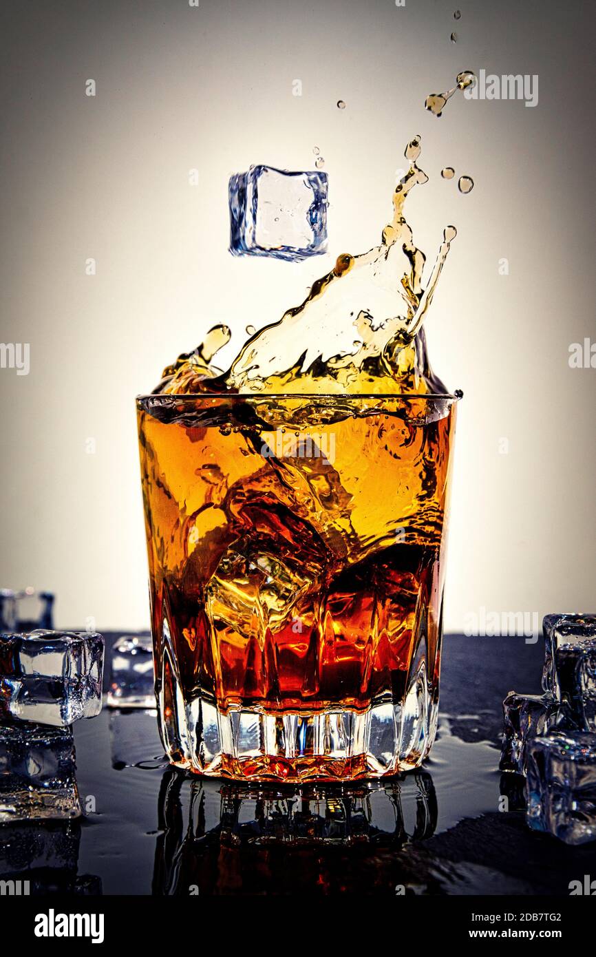 Photo of a drink on ice in a glass, with a falling ice cube Stock Photo ...