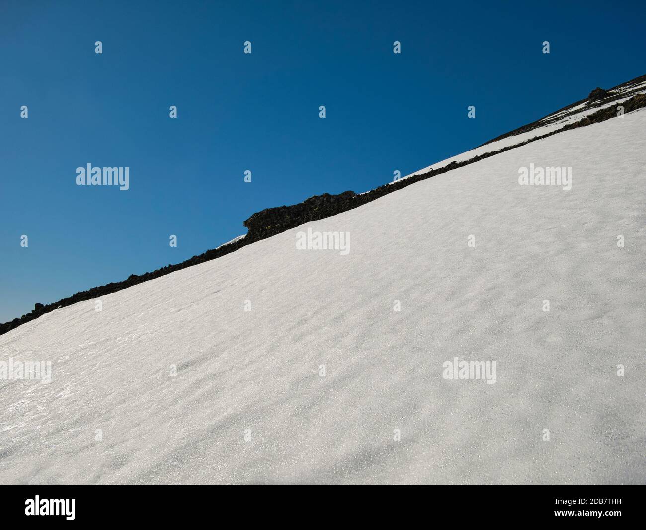 A mountain slope in Iceland with volcanic rock and shiny snow Stock ...