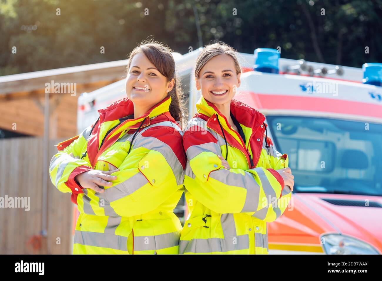 Paramedic and emergency doctor standing proud in front of ambulance ...
