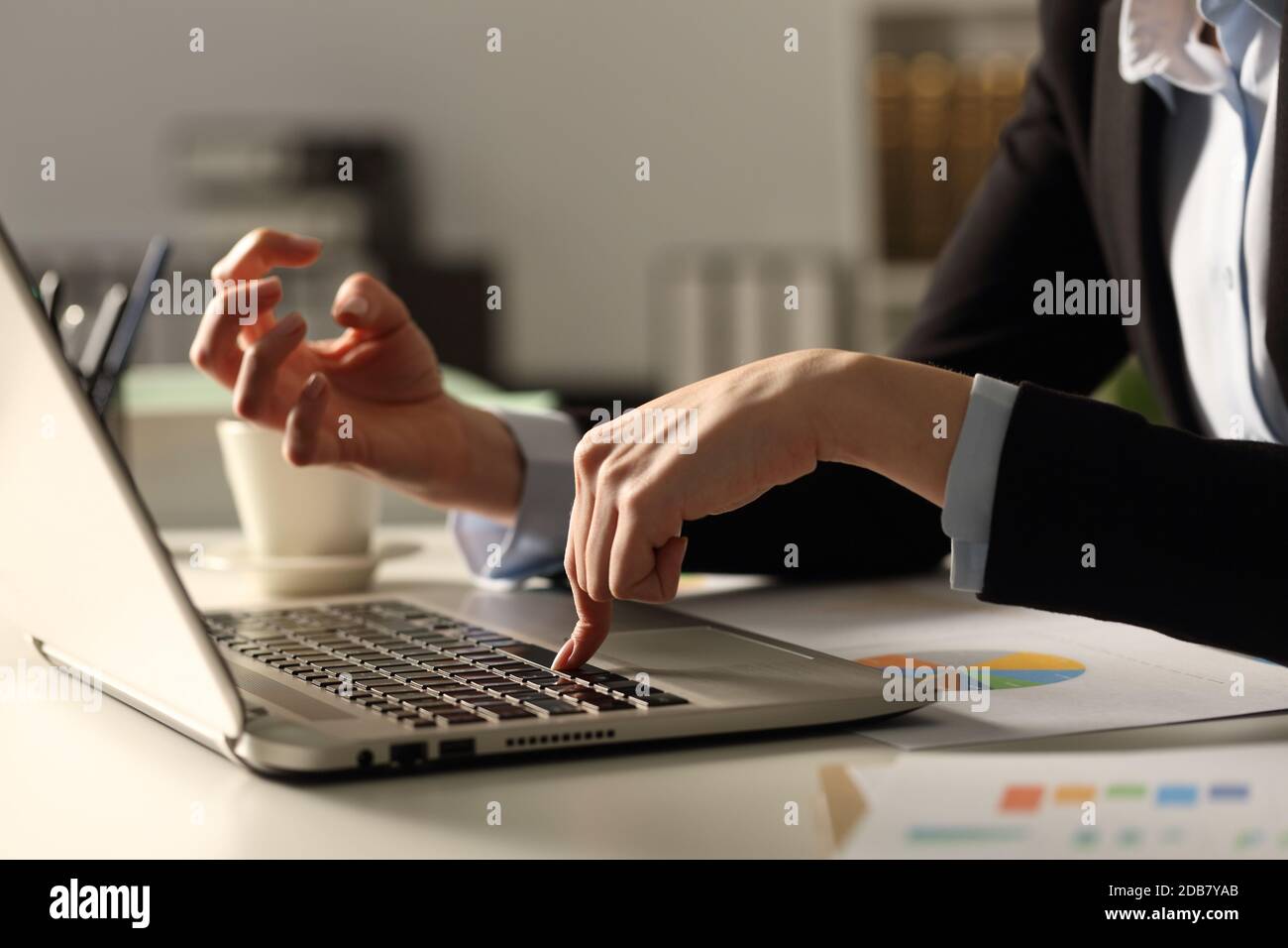 Close up of angry executive woman hands pushing keybord button at night ...