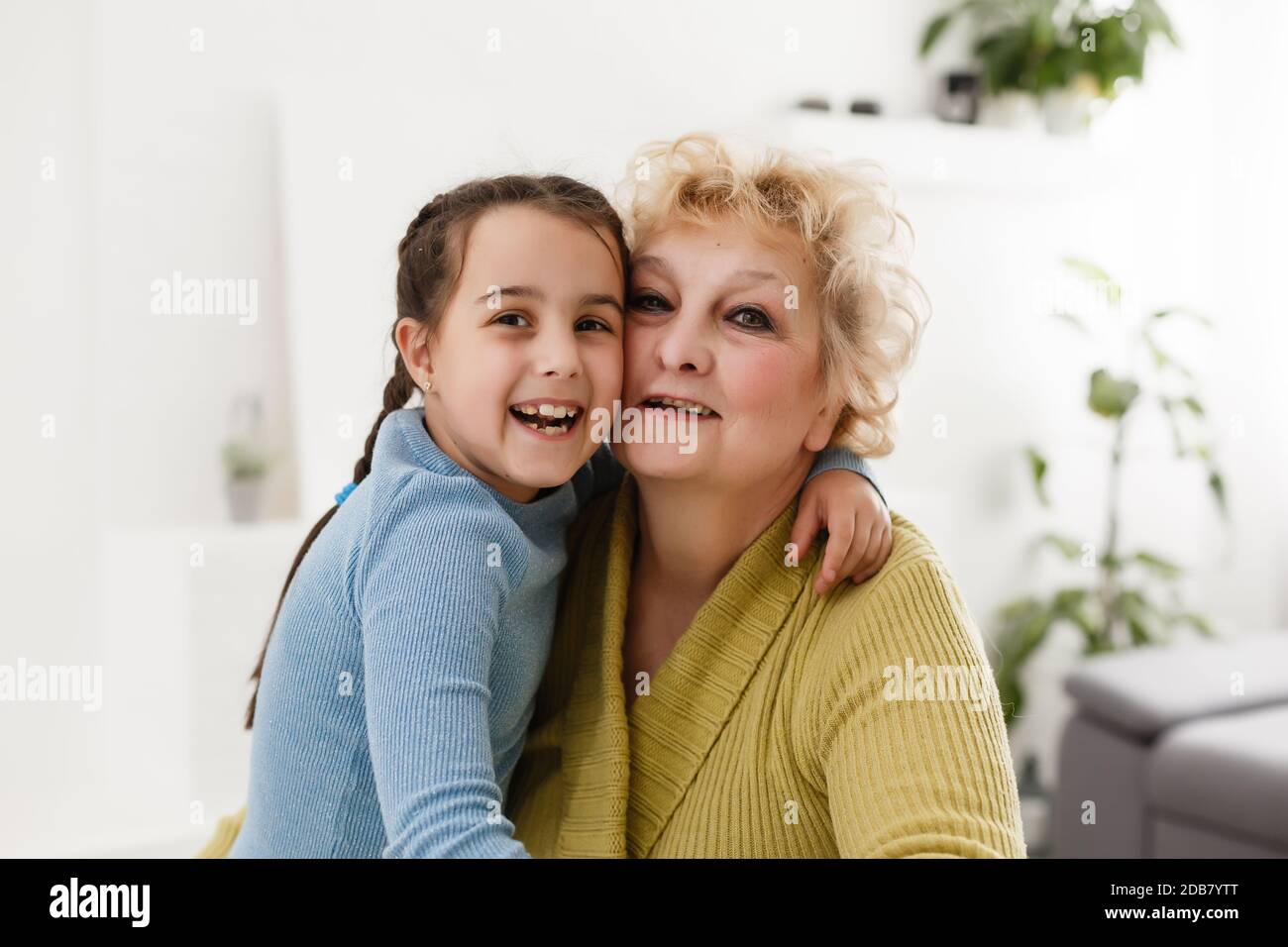 Portrait of happy old grandmother and kid girl looking at camera ...