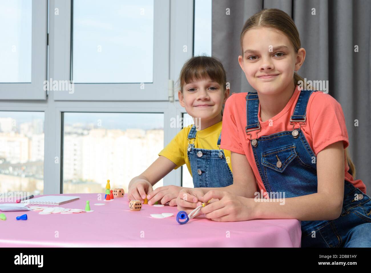 Two girlfriends play board games for children and looked at the frame ...