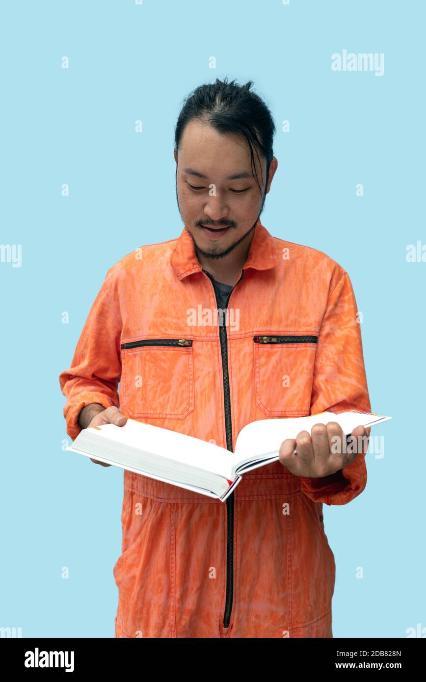 The chief mechanic in an orange uniform holding big book. Stand and ...