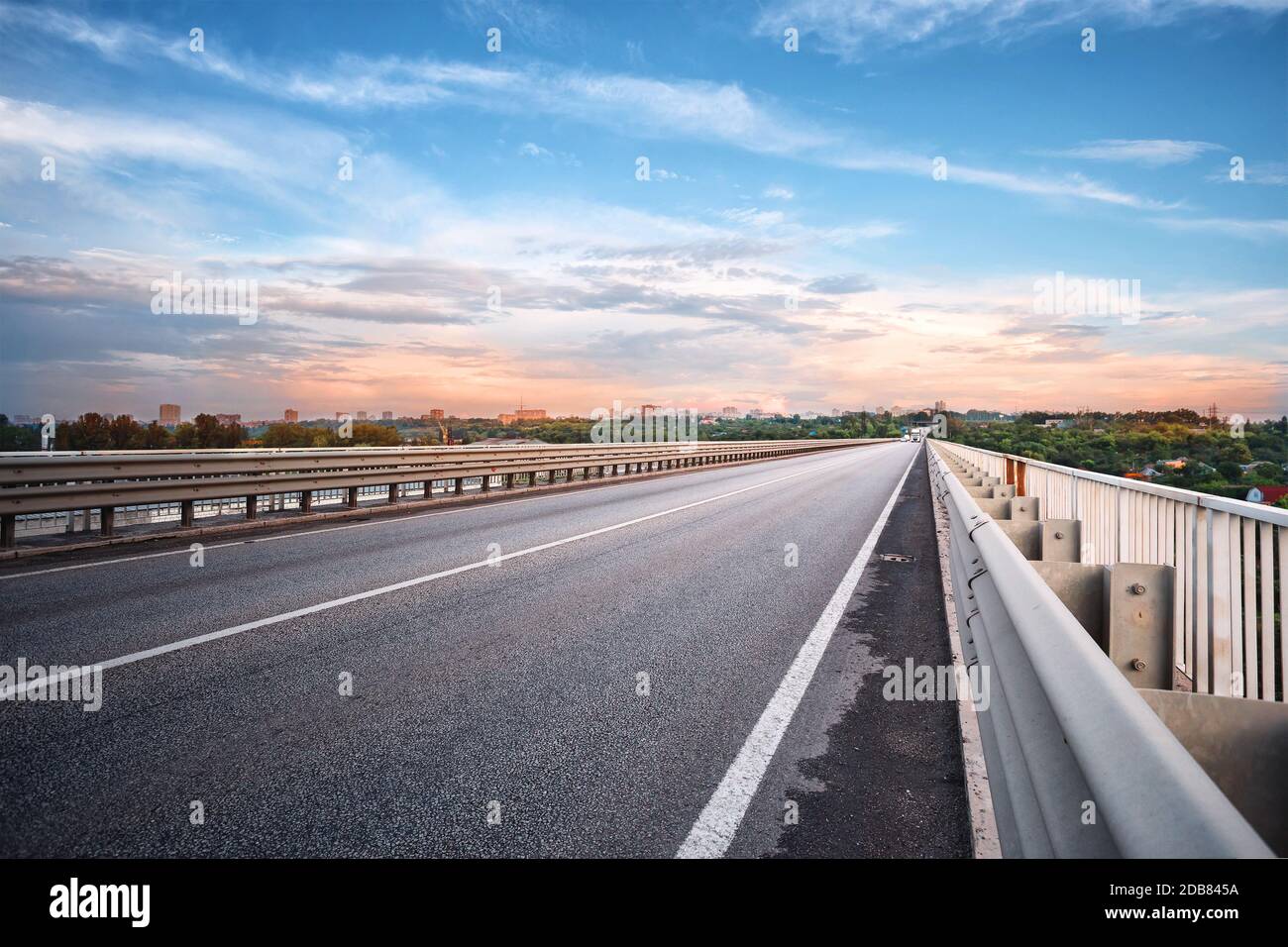 Asphalt road bridge at sunset Stock Photo - Alamy