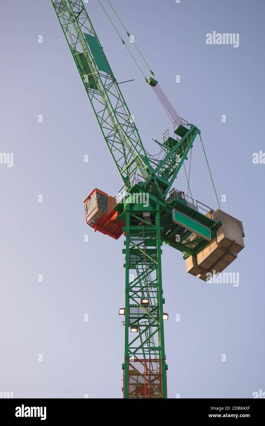 Vertical sunrise image looking up at a tall green and orange tower ...