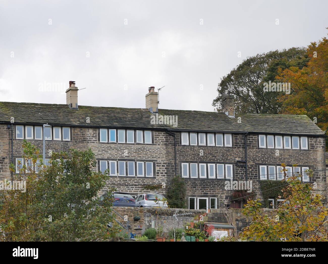 Row of four three story stone built weavers cottages with rows of small ...