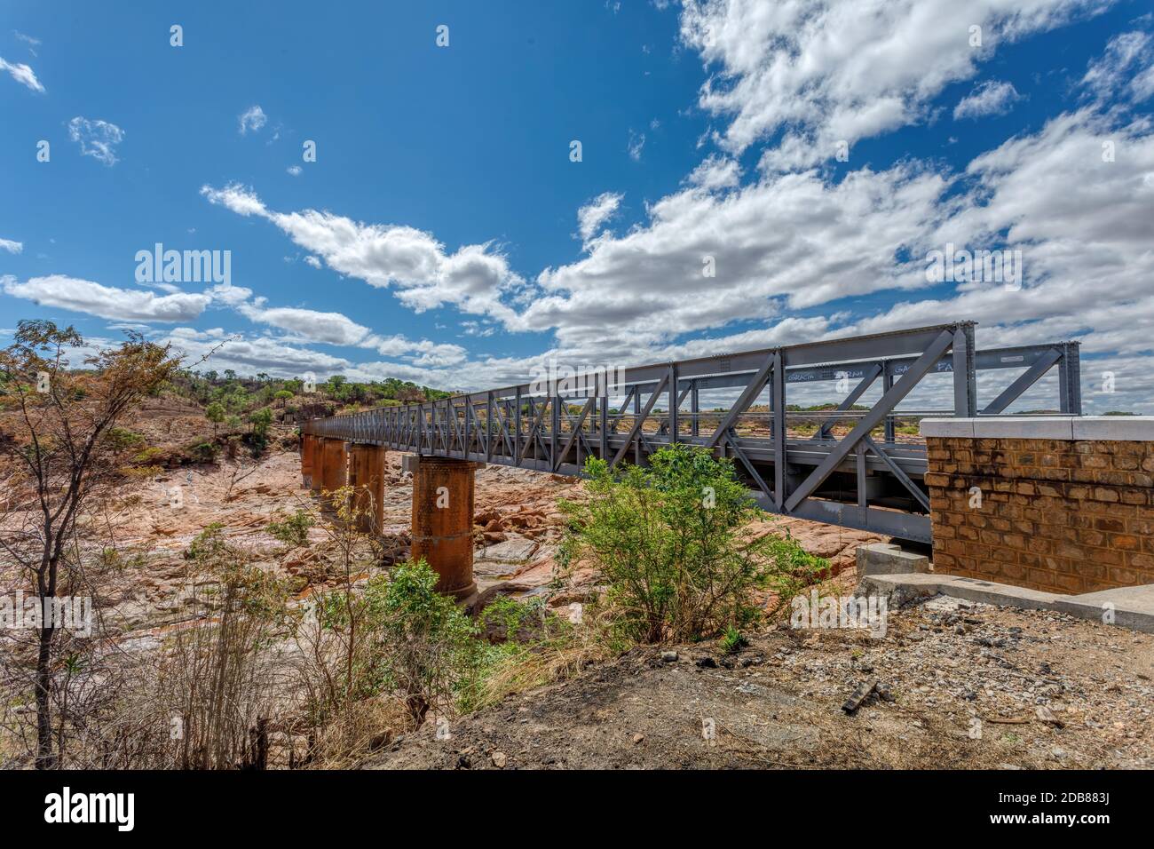 bridge over rocky river bed Betsiboka river after heavy rain, red water ...