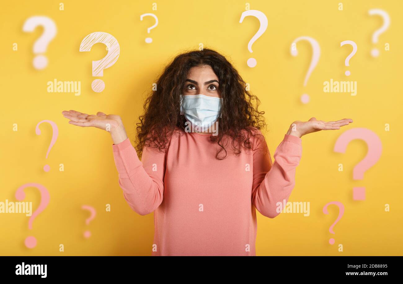 Girl with face mask has a lot of question about covid 19. Yellow ...