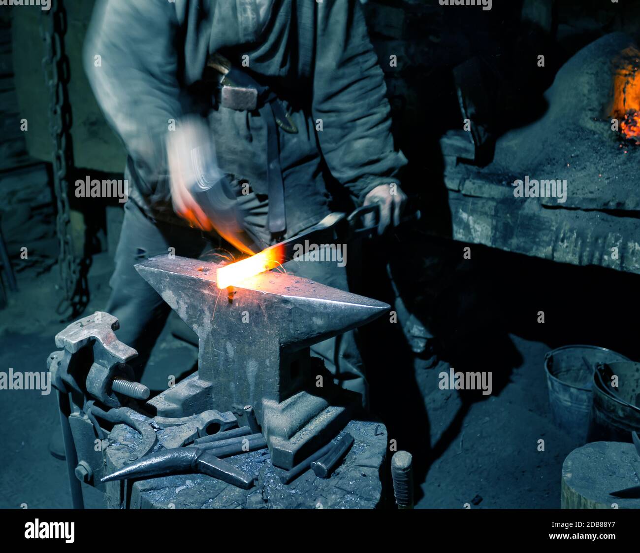 The blacksmith's hands with the smith's hammer are hot metal heated ...