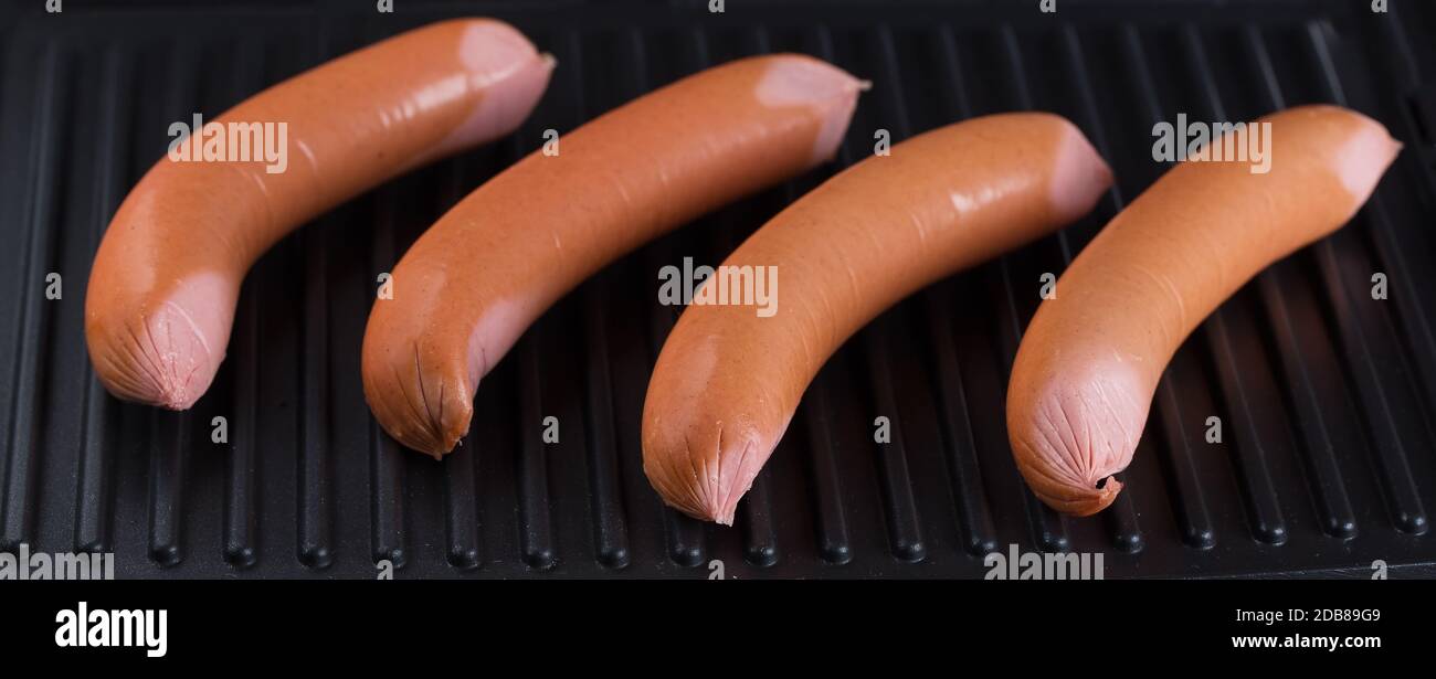 Raw sausages on the surface of the grill. The concept of traditional ...
