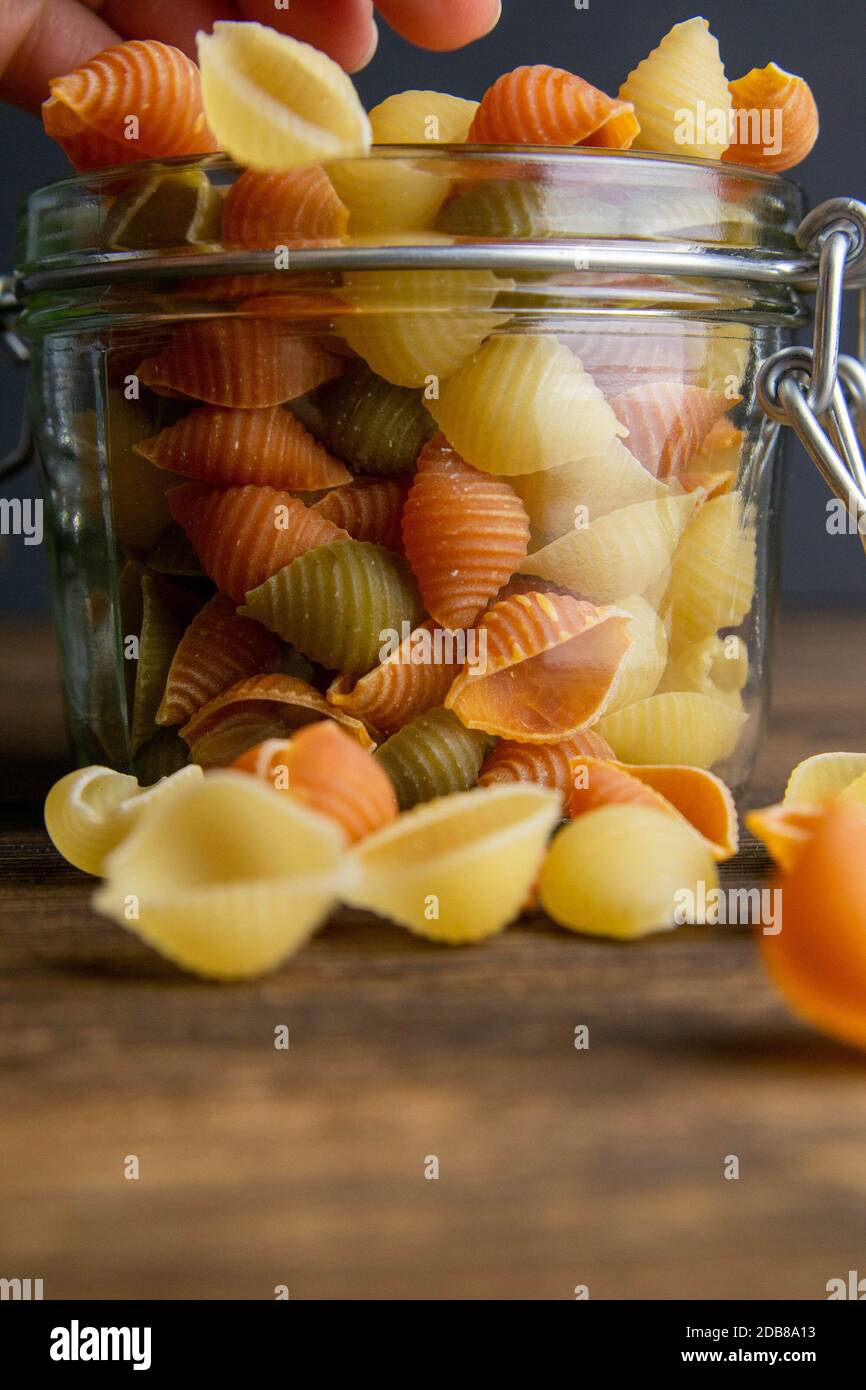 Colorful Conchiglie Pasta in Glass Jar on Wooden background. Front ...